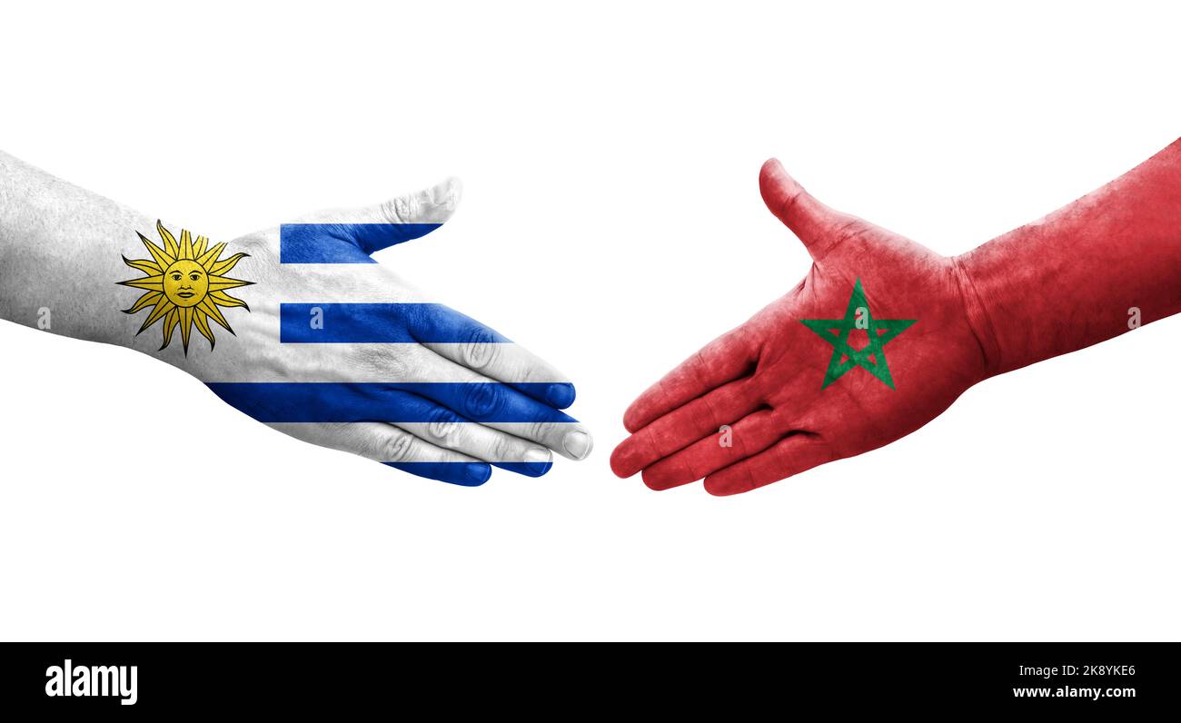Handshake between Morocco and Uruguay flags painted on hands, isolated ...