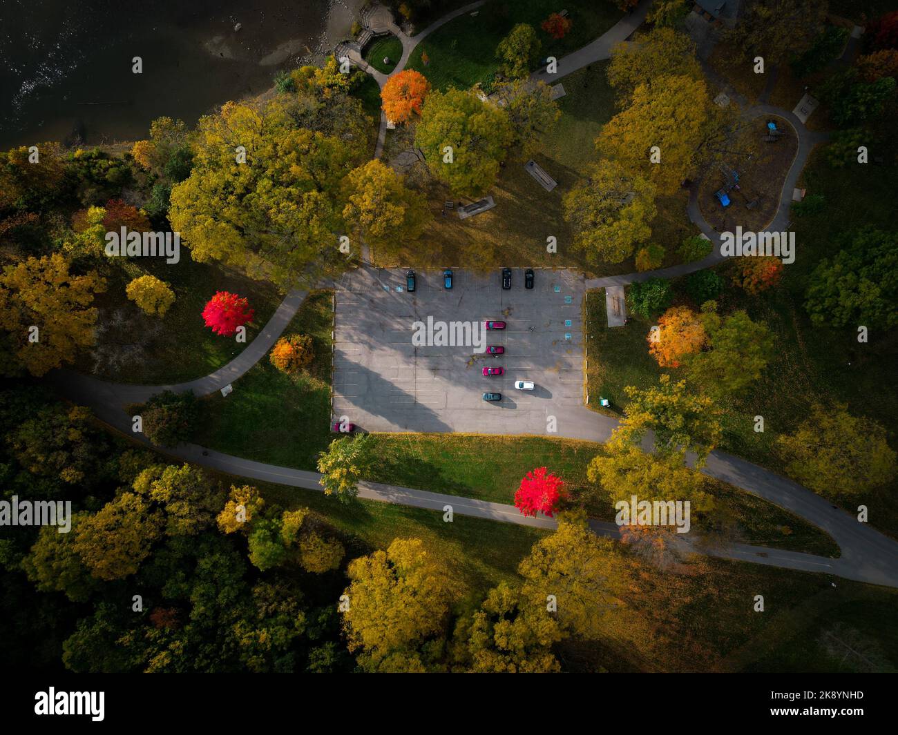 An aerial view of a parking lot surrounded with trees in autumn foliage ...