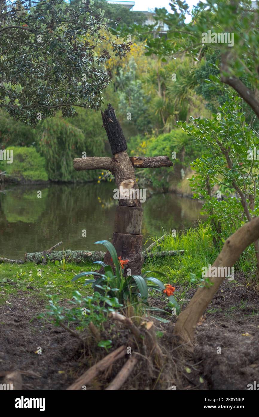 A vertical shot of a wooden sculpture made from logs with trees and a ...
