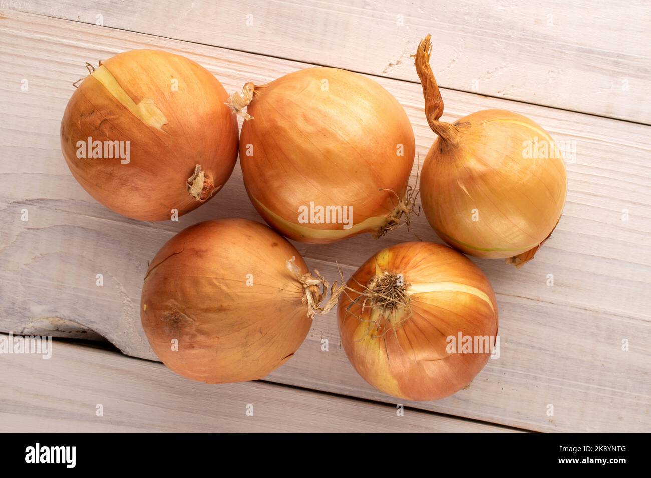 Four organic onions, close-up, on a wooden table, top view Stock Photo ...