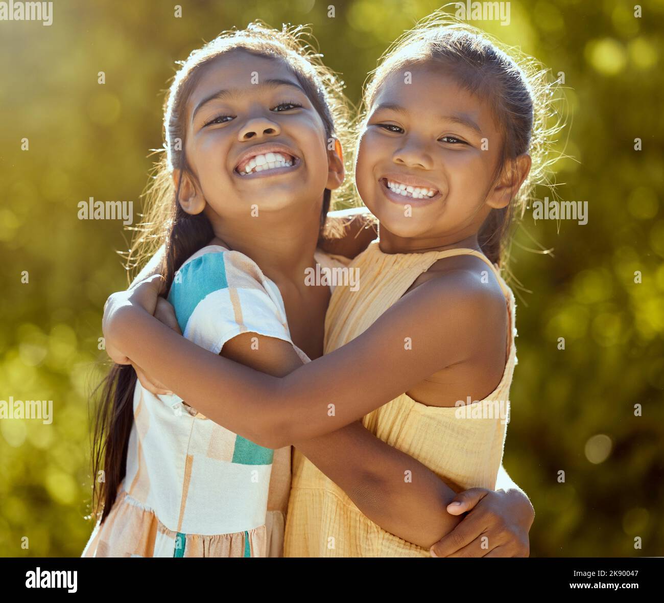 Happy children, sisters and girl friends hug for love, care and bond in sun park, summer garden ...