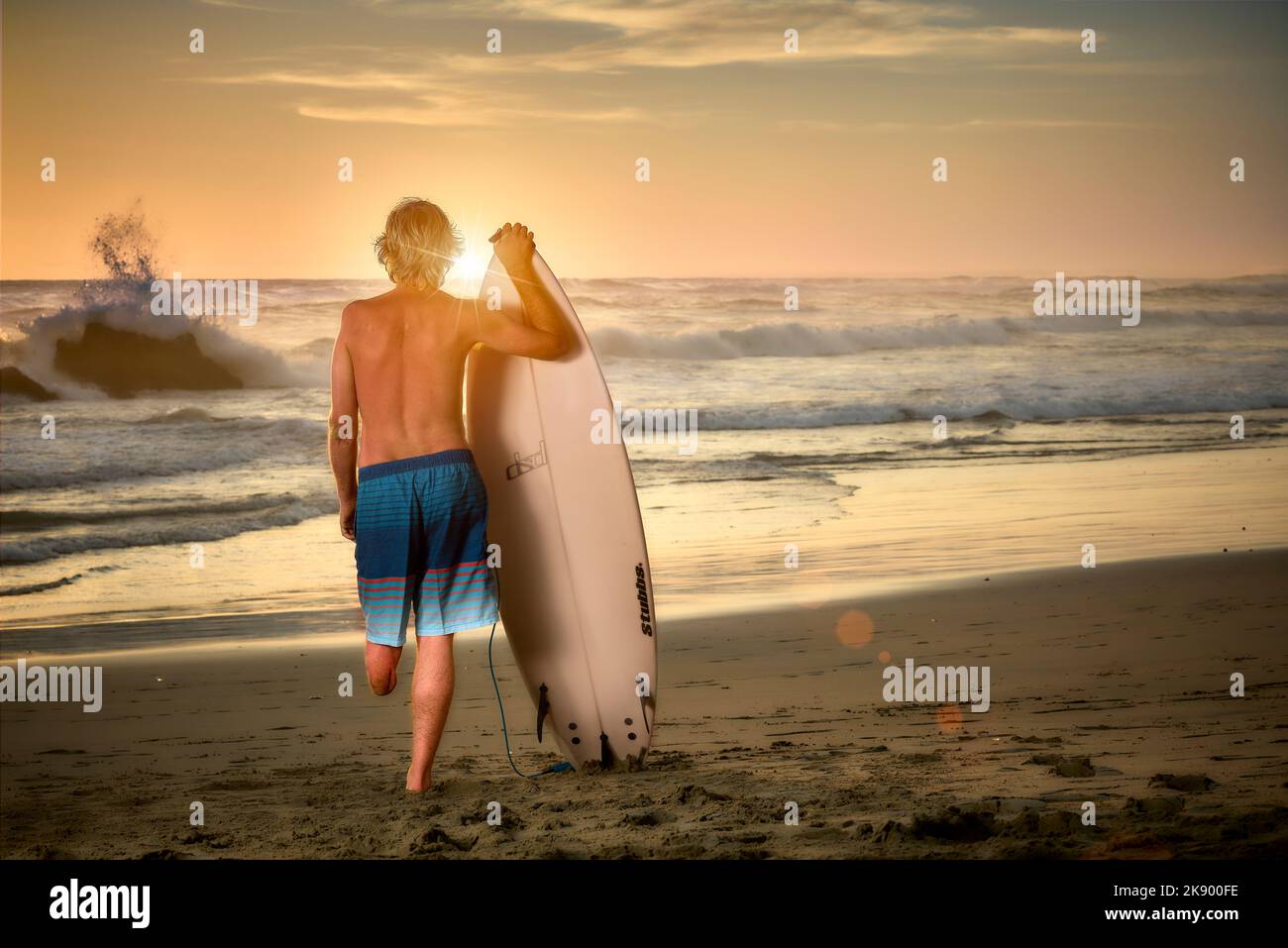 One legged surfer on beach looking out to sea at sunset Stock Photo - Alamy
