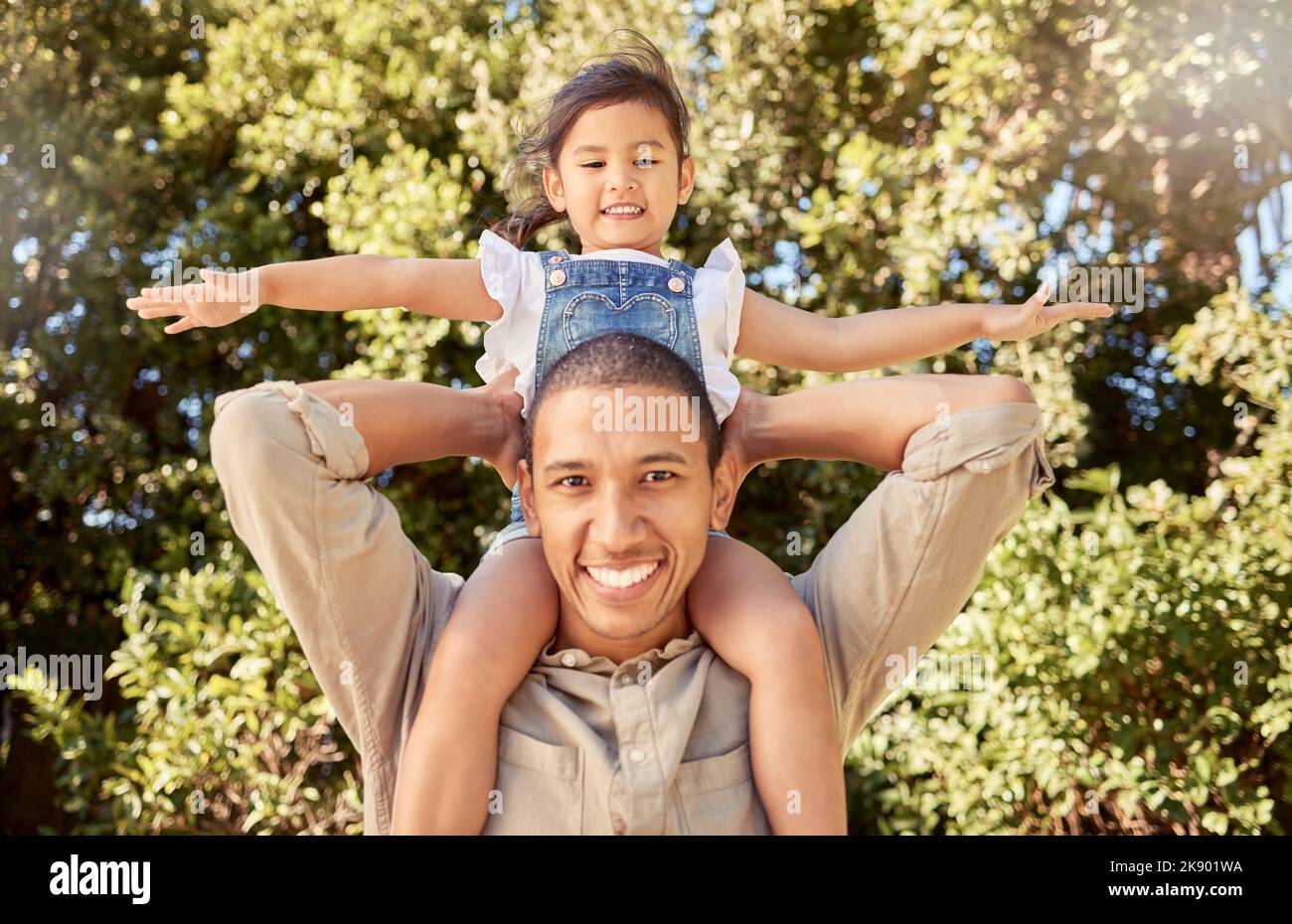 Girl child on shoulder of father, forest adventure with trees .or happy ...