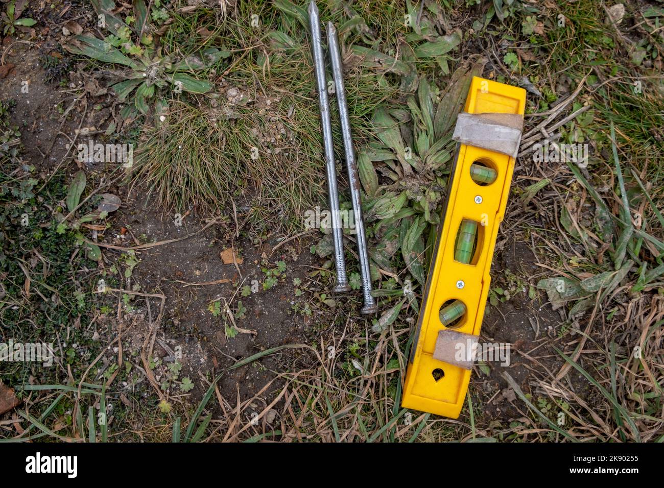 two large steel nails together with a hand level, archeology works ...