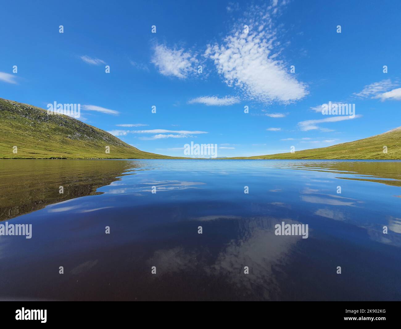 A beautiful scene of blue sky reflecting on Coire- Fhionn Lochan lake ...