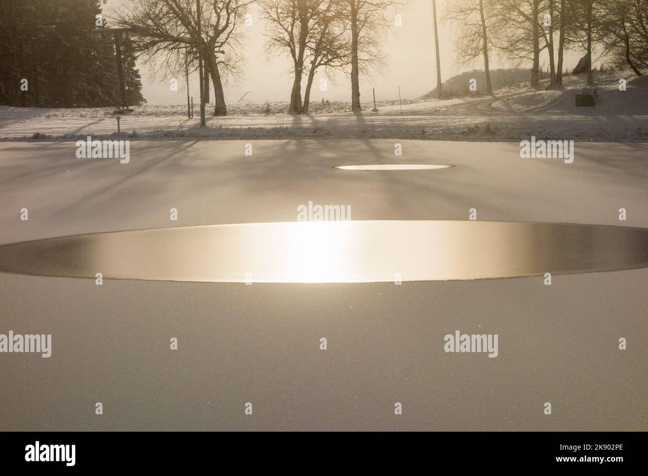 Melted water pole on the lake in back light Stock Photo - Alamy