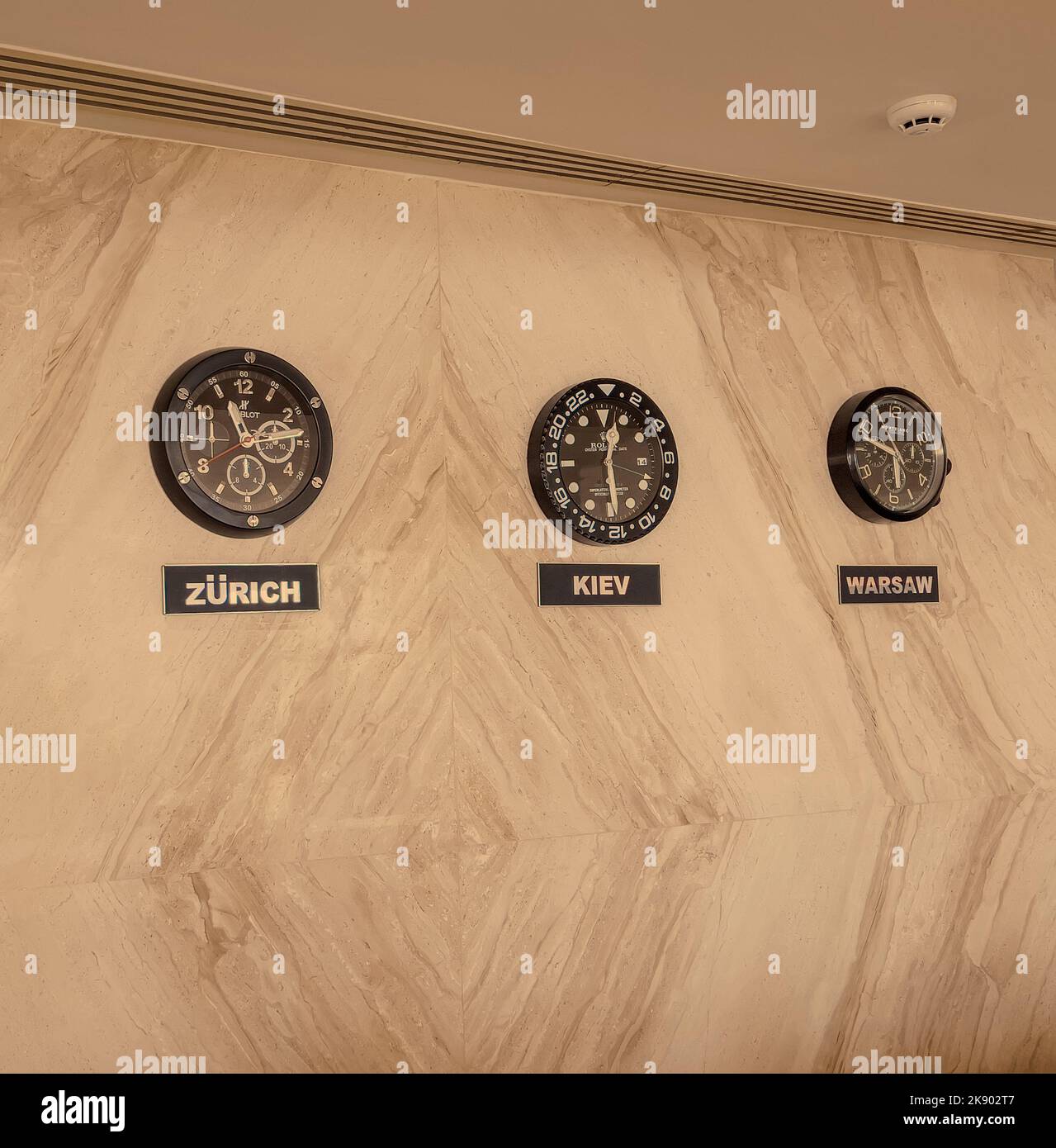 In the hotel, the clock on the wall shows the time in various cities of ...