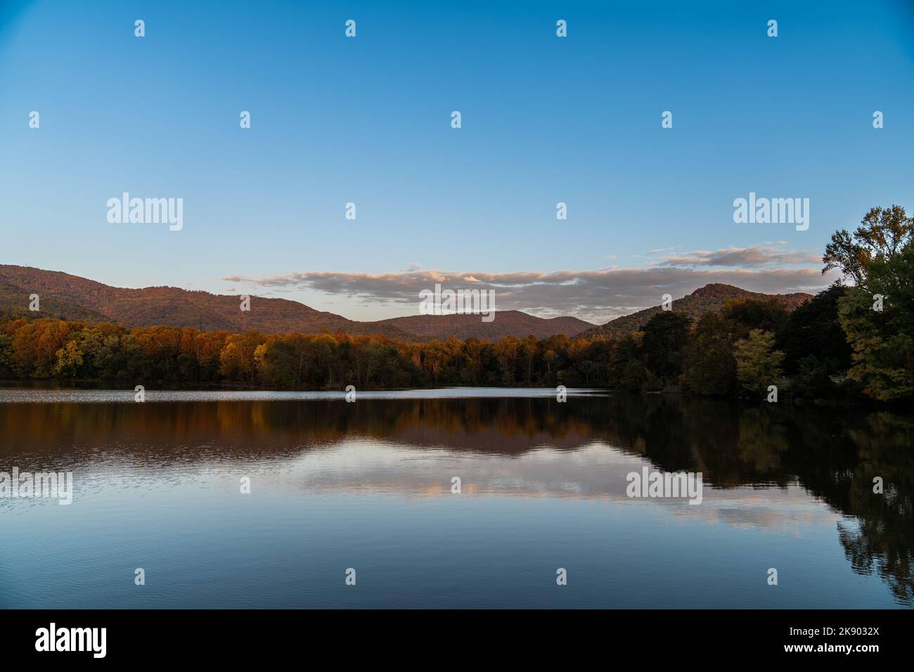 A large lake reflecting mountains covered with dense forest in the ...