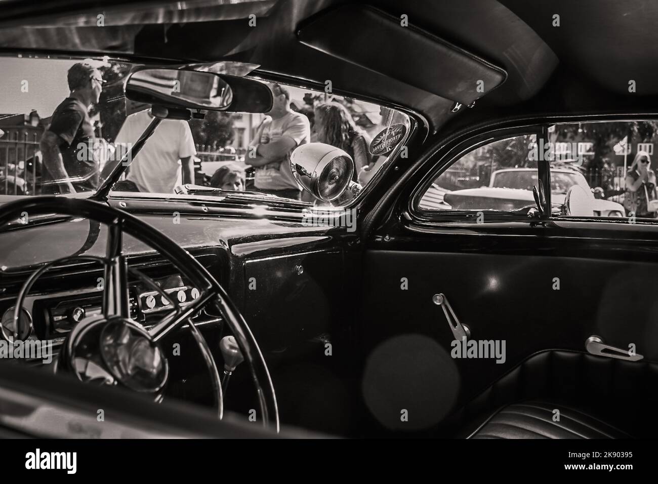 A greyscale shot of the interior salon of a classic car during a car ...