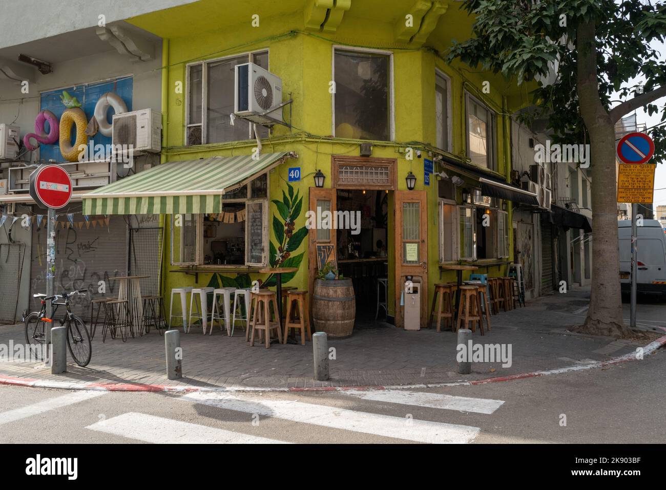 A yellow cafe restaurant on the corner of the street with chairs ...