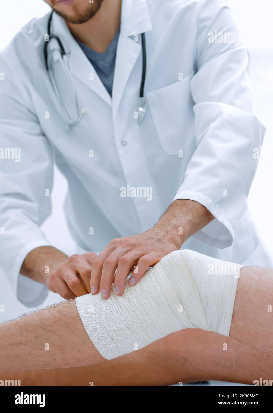 doctor looking at the bandage on the patient's leg Stock Photo - Alamy