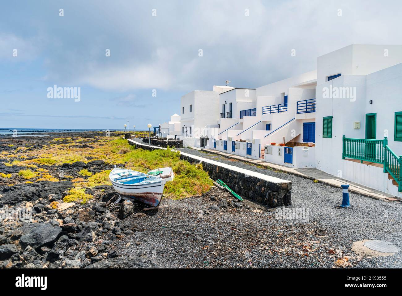 White buildings with blue and green windows by the ocean in Corralejo ...