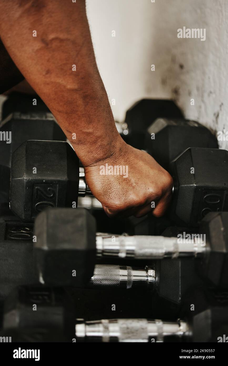 Hand, dumbbell and fitness with a man bodybuilder in a gym for exercise ...