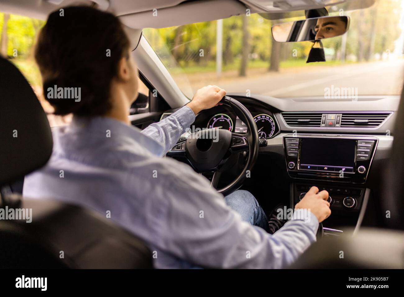 Businessman in car. Rear view of young handsome man looking on the ...