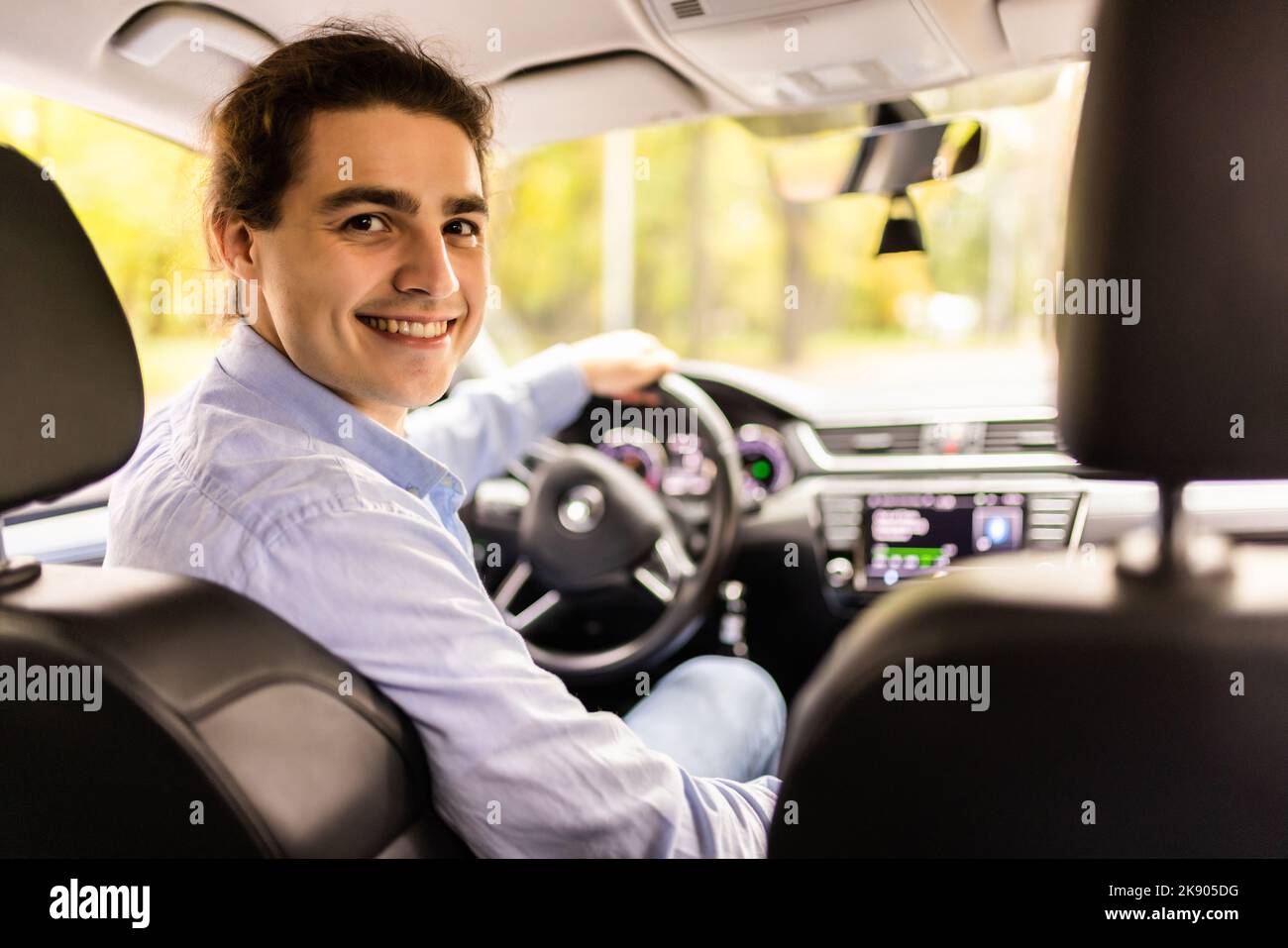 transport, vehicle and driving concept - man or car driver looking back ...