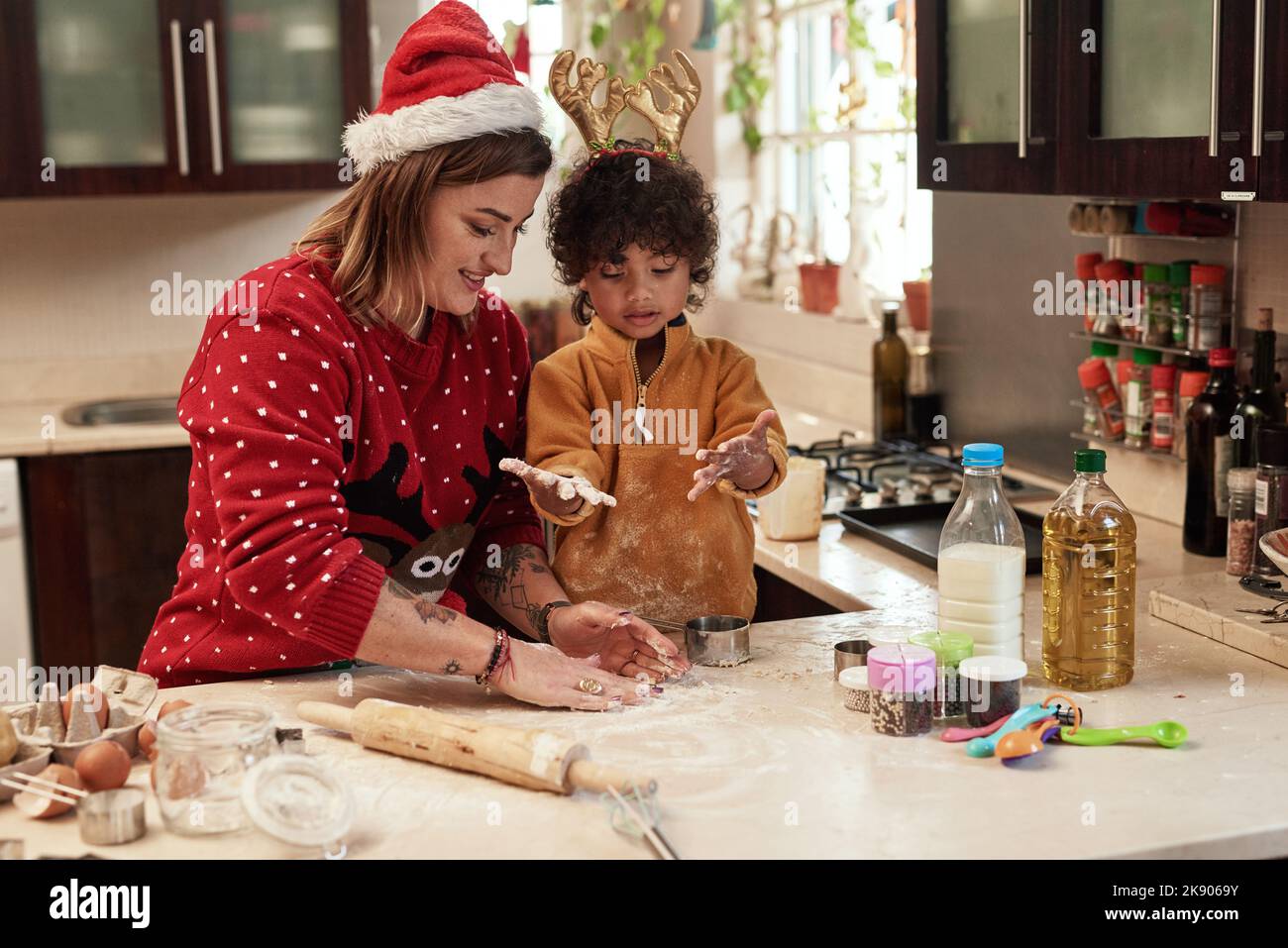 We both have messy hands. a cheerful young woman and her son baking ...