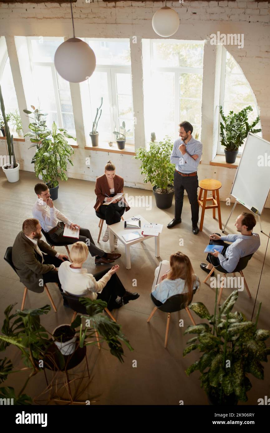 Aerial view of young people talking, working, discussing problems and ...