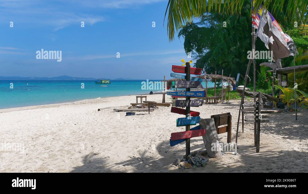 The signs on the sandy, tropical beach showing direction, and the ...