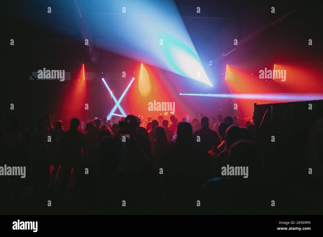 A crowd of people dancing under neon lights at night during the ...