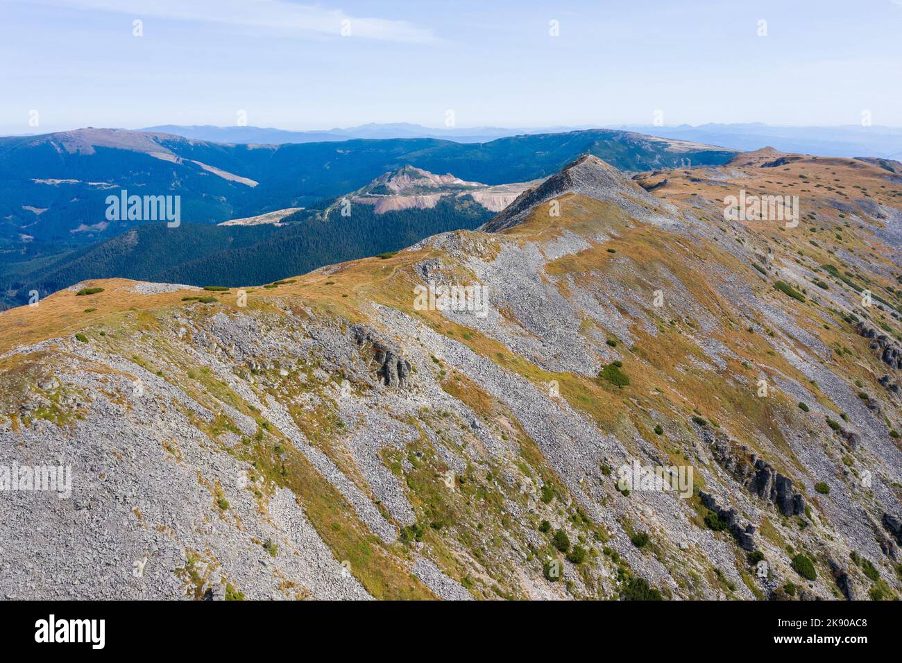 Stunning view of blue cloudy sky over layered mountain ranges and valley covered with vegetation ...