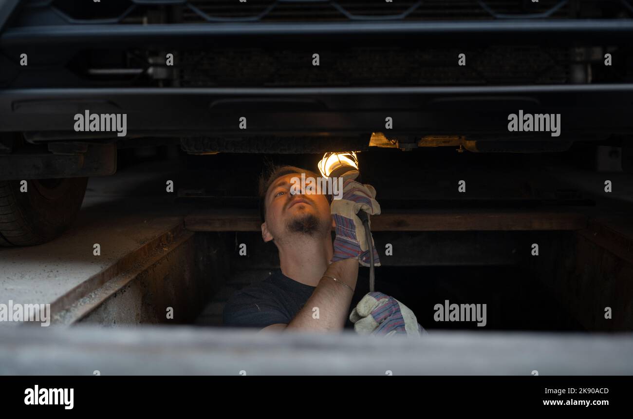 The mechanic services the car under the car Stock Photo - Alamy
