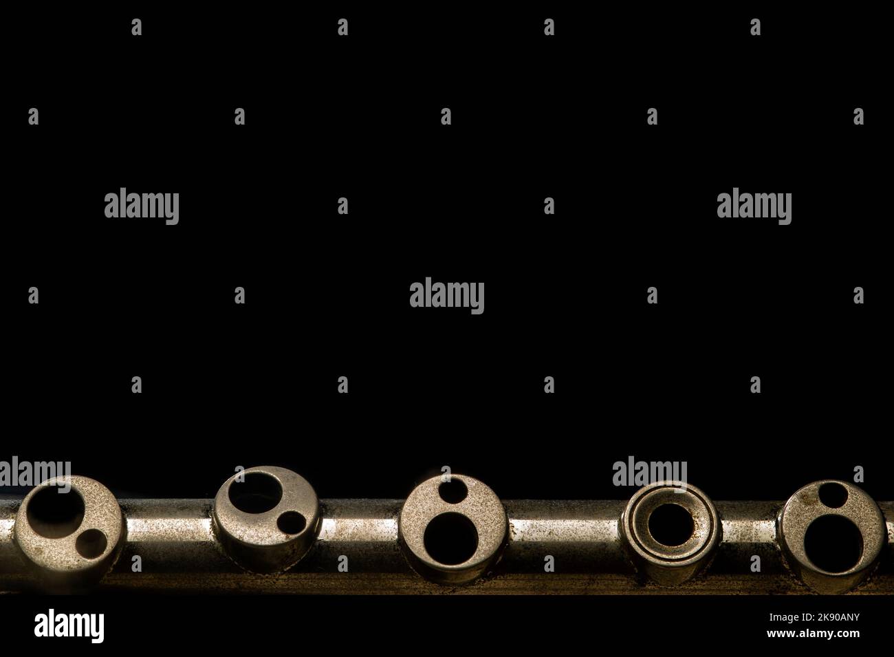 A Hole detail of an old flute display isolated on black background ...