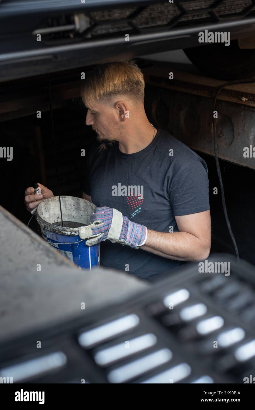 The mechanic services the car under the car Stock Photo - Alamy