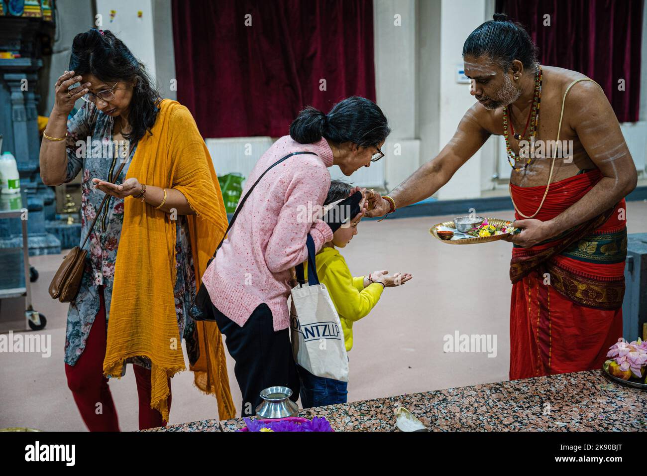 A pandit or Hindu Priest performs puja and gives his blessings to a ...
