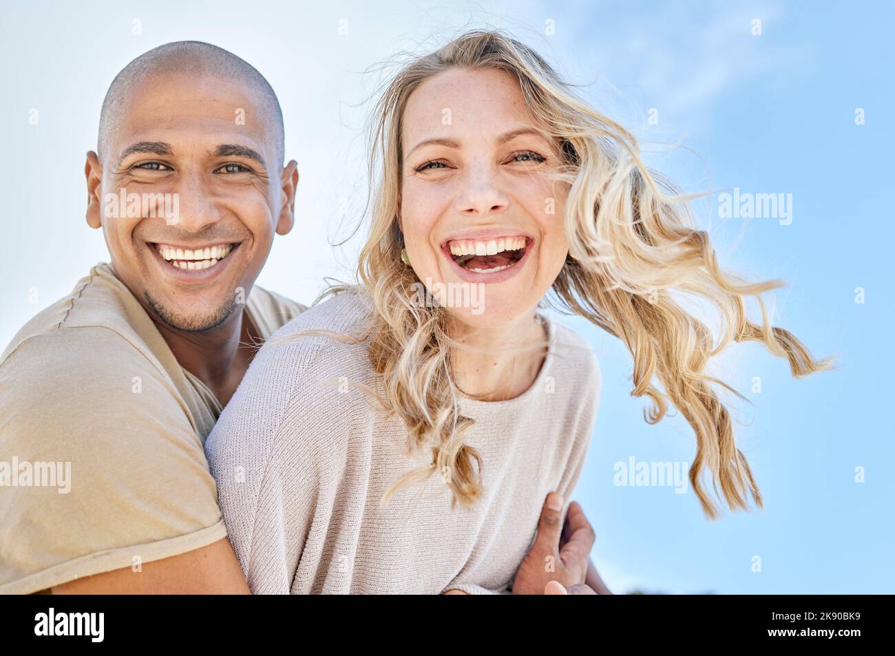 Love, blue sky and diversity couple hug, laugh and enjoy fun quality ...