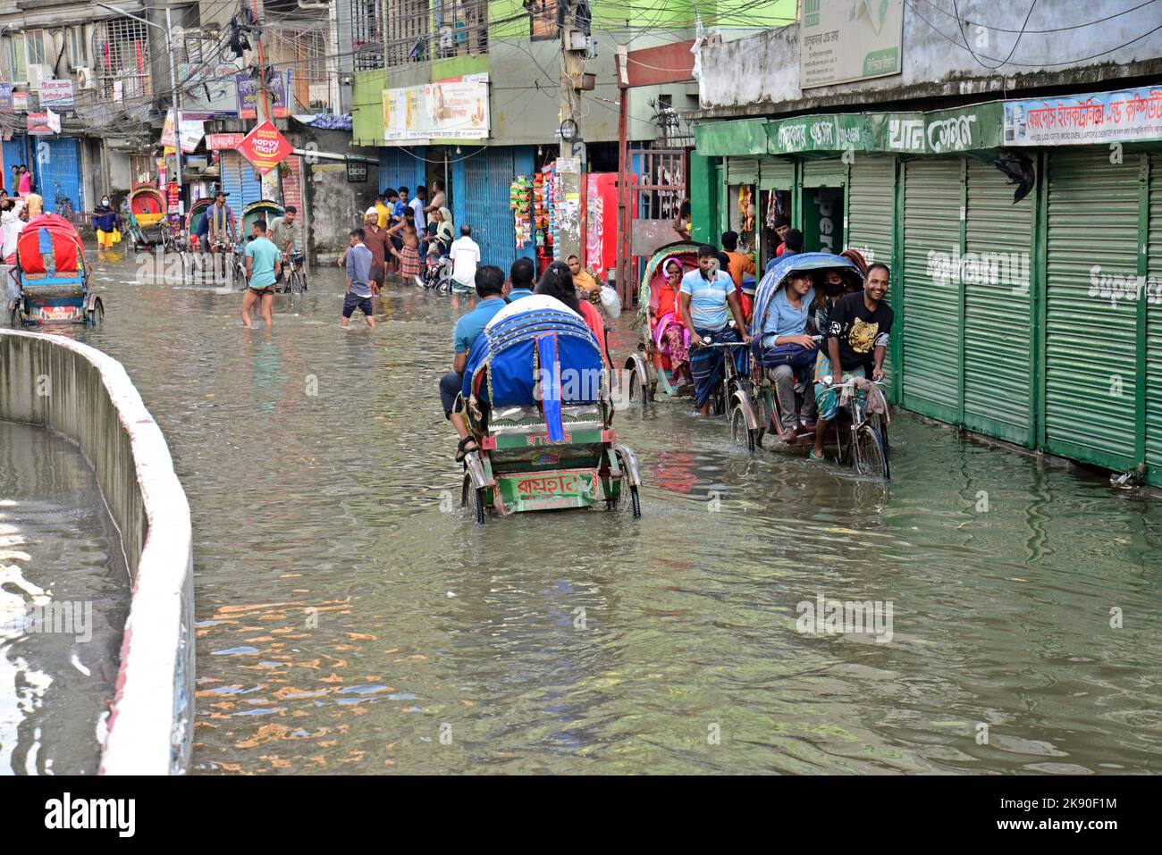 Rickshaws try driving with passengers through the flooded street of ...