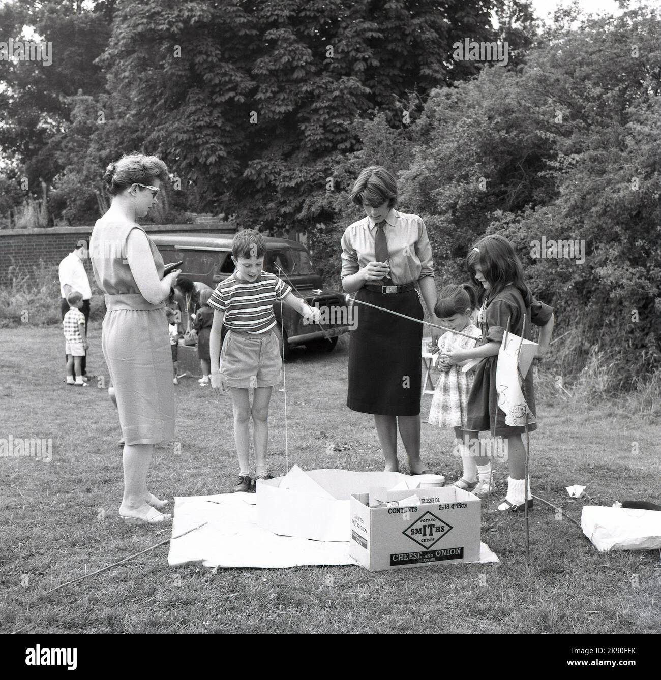 1964, historical, july and young children outside at a fete playing a ...