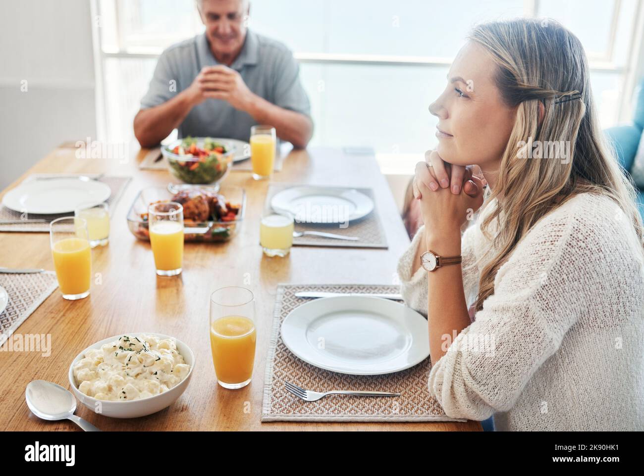 Woman, thinking at the dinner table in gratitude for food, family and ...