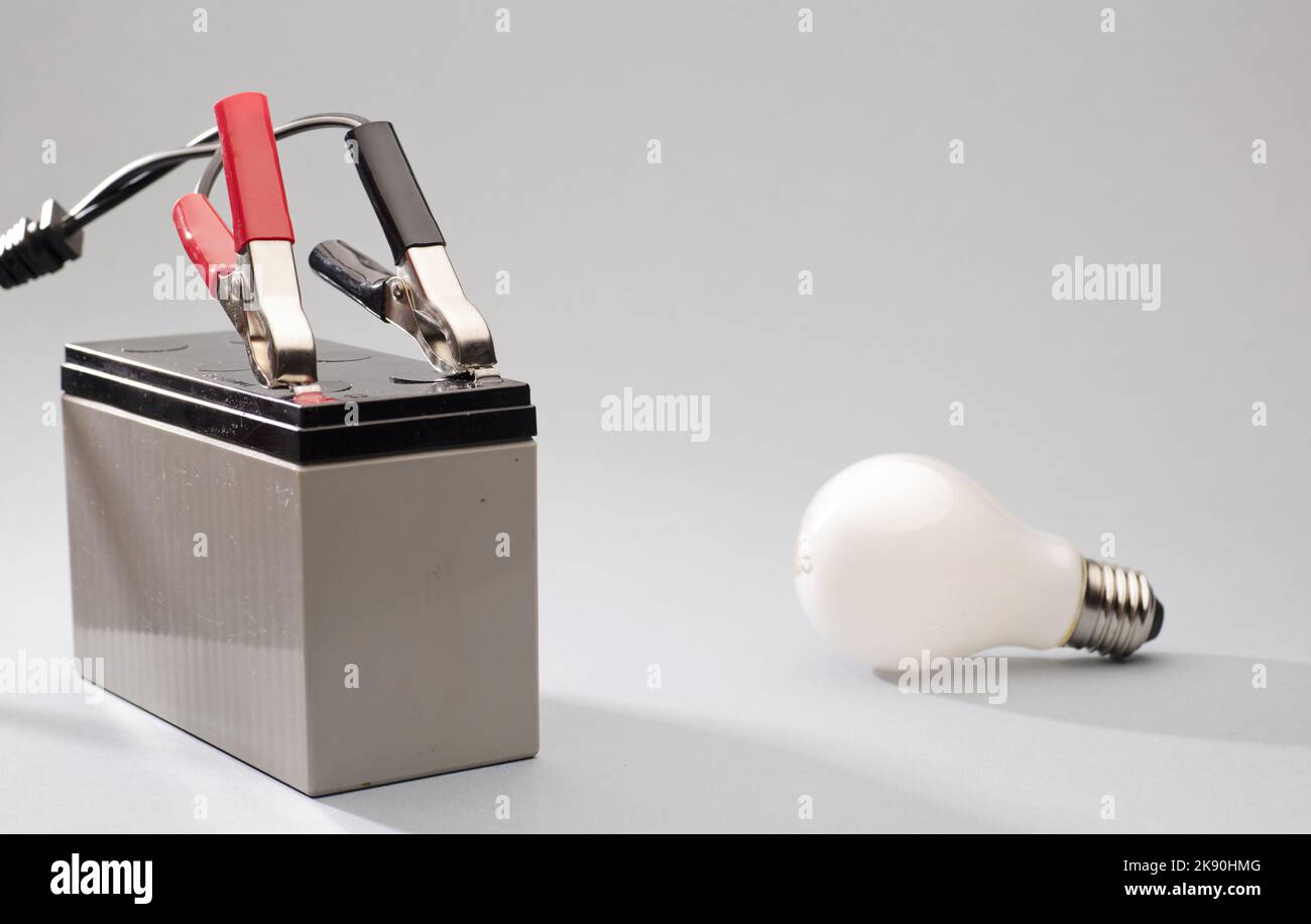 battery bolts connected to 12v, with bulb off gray background Stock ...