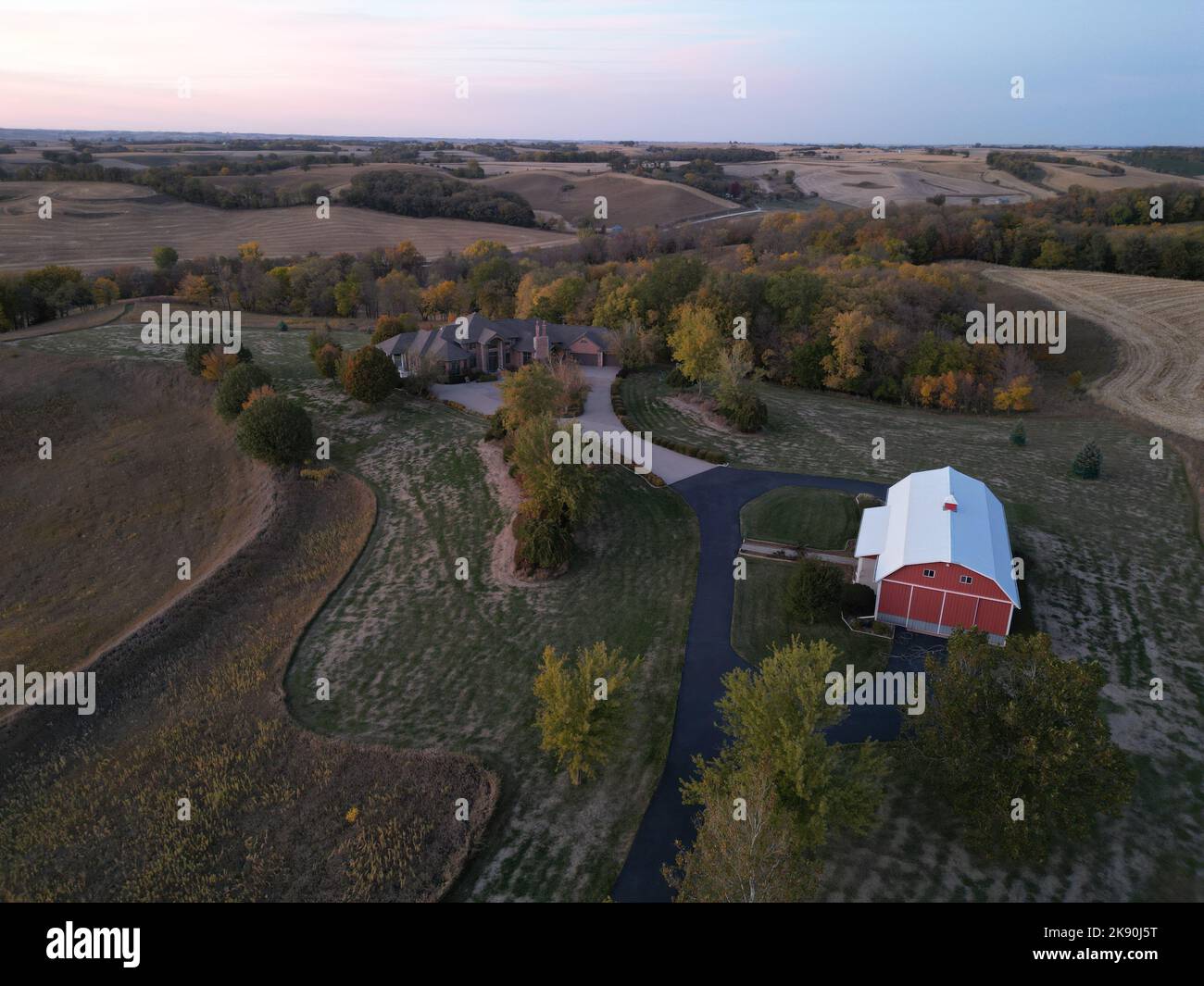 an aerial view of Iowa countryside with a shed house at sunset in fall ...