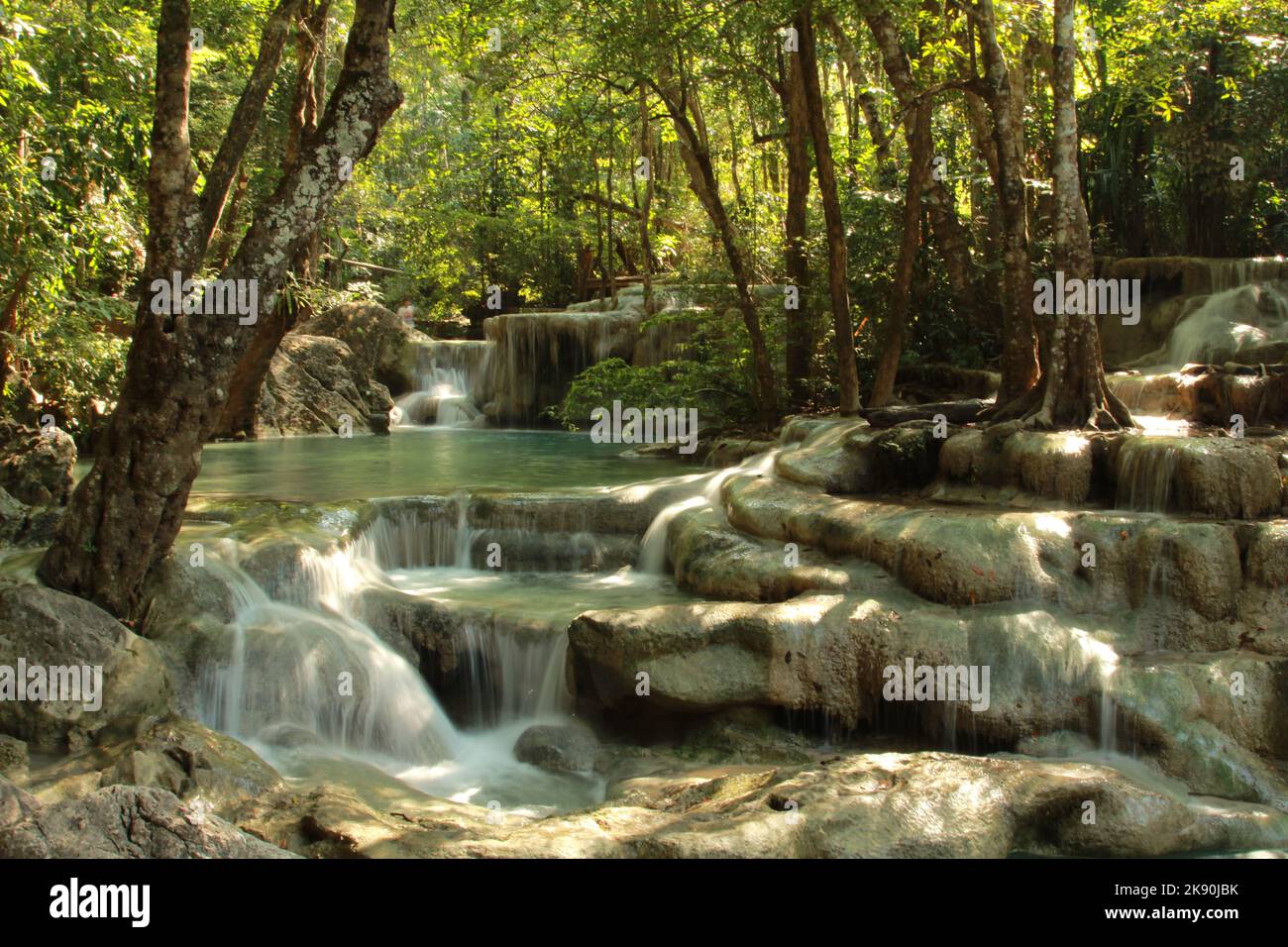 A scenic shot of a flowing water cascade surrounded by woods and ...