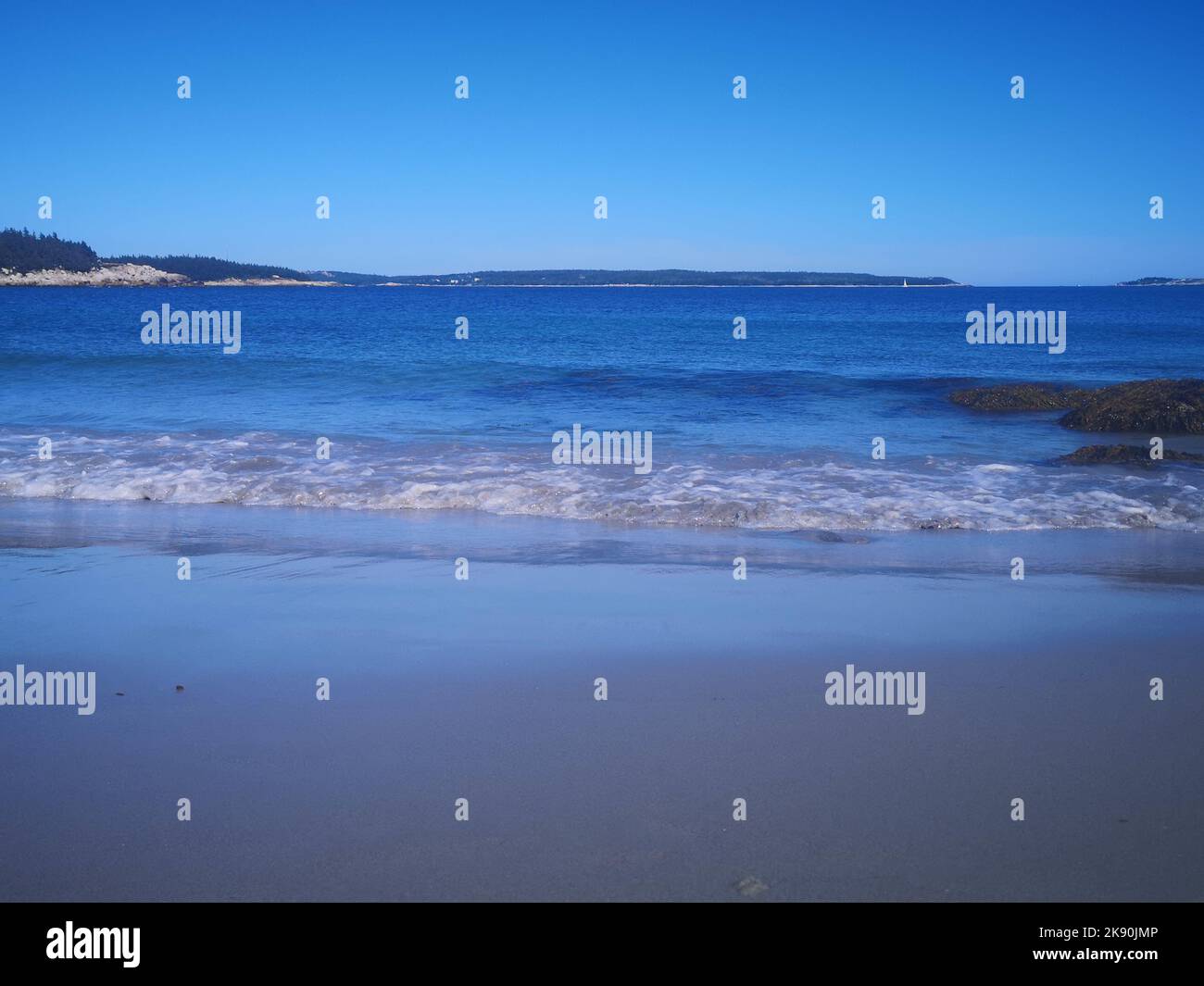 A scenic display of calm sea waves hitting the shoreline with smooth ...