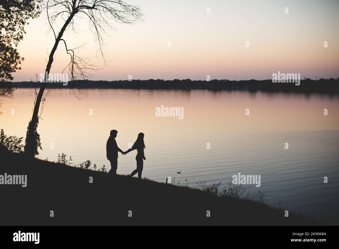 Romantic couple walking hand in hand by the lakeshore Stock Photo - Alamy