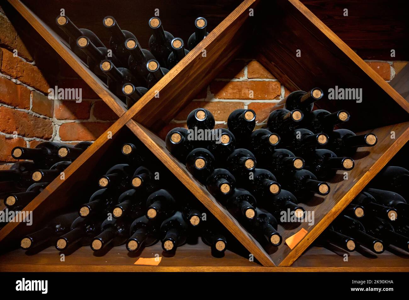 Rhomboid wine rack with multiple bottles of red and white wine lying in ...