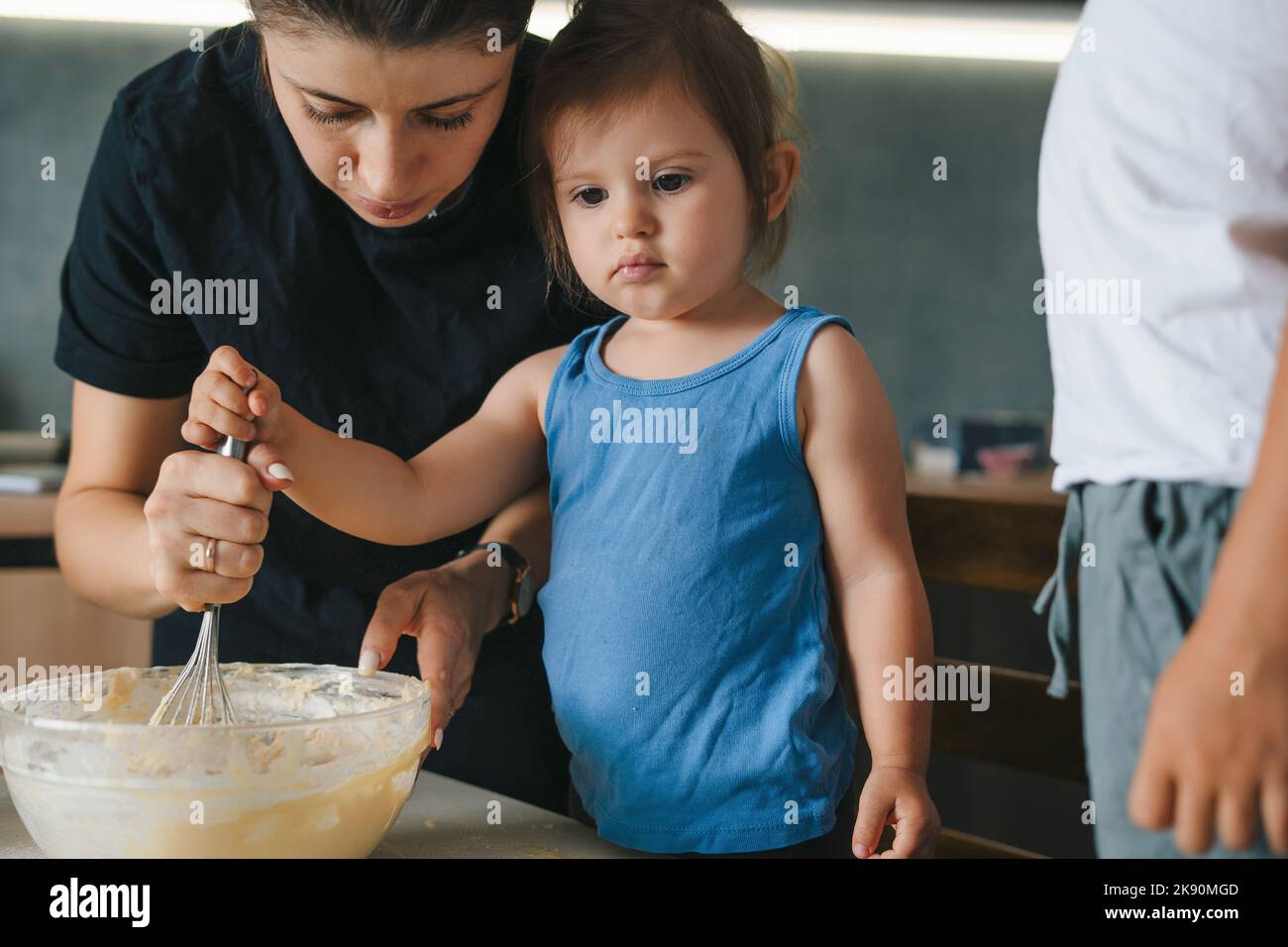 Little girl with her mother mixing ingredients in big bowl to make ...