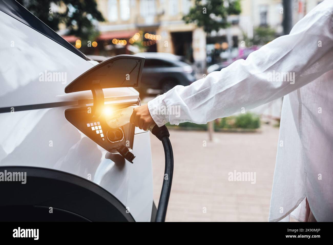 Human hand is holding Electric Car Charging nozzle Stock Photo - Alamy