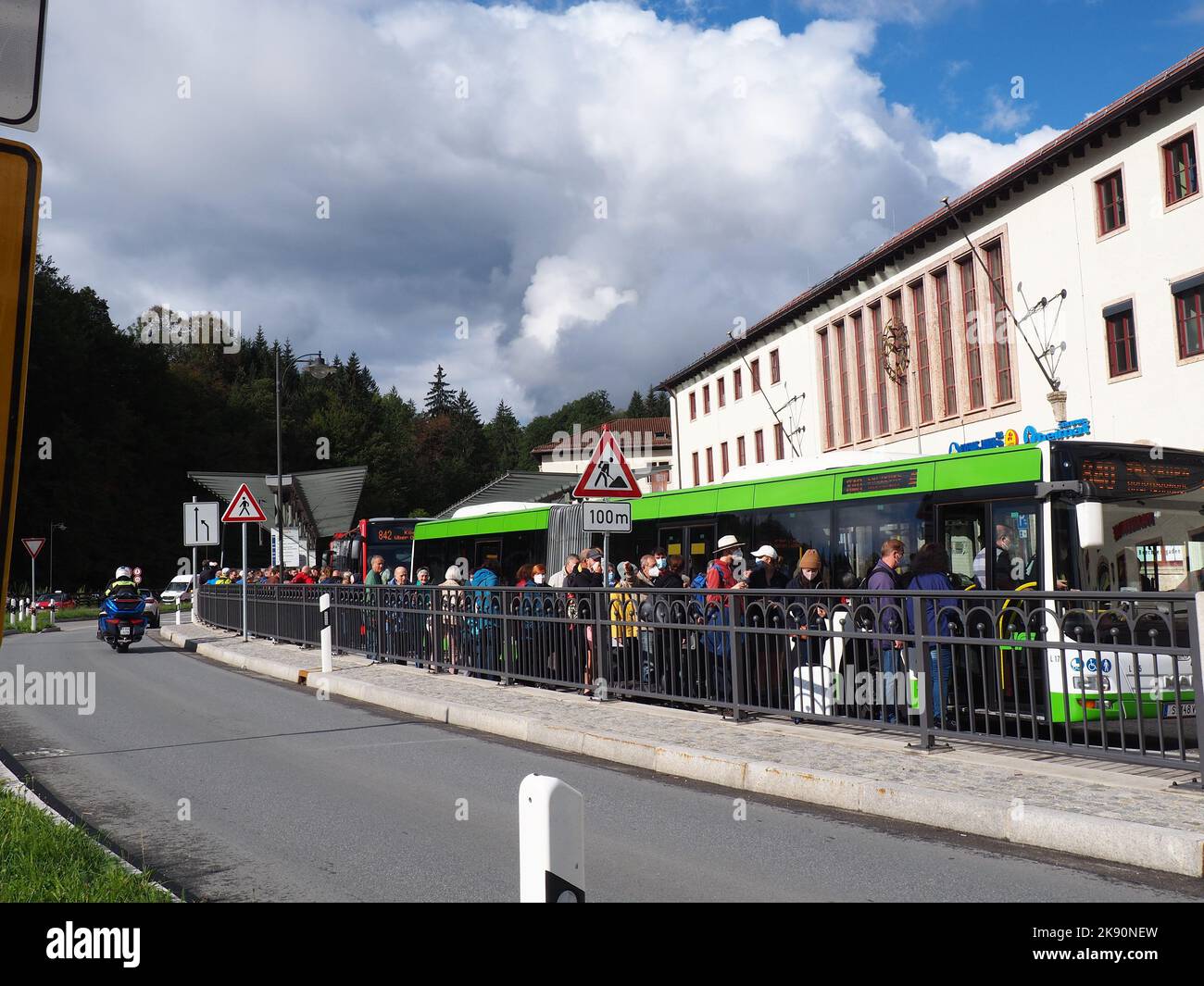 A group of people getting on the 840 bus to Salzburg at a station in ...