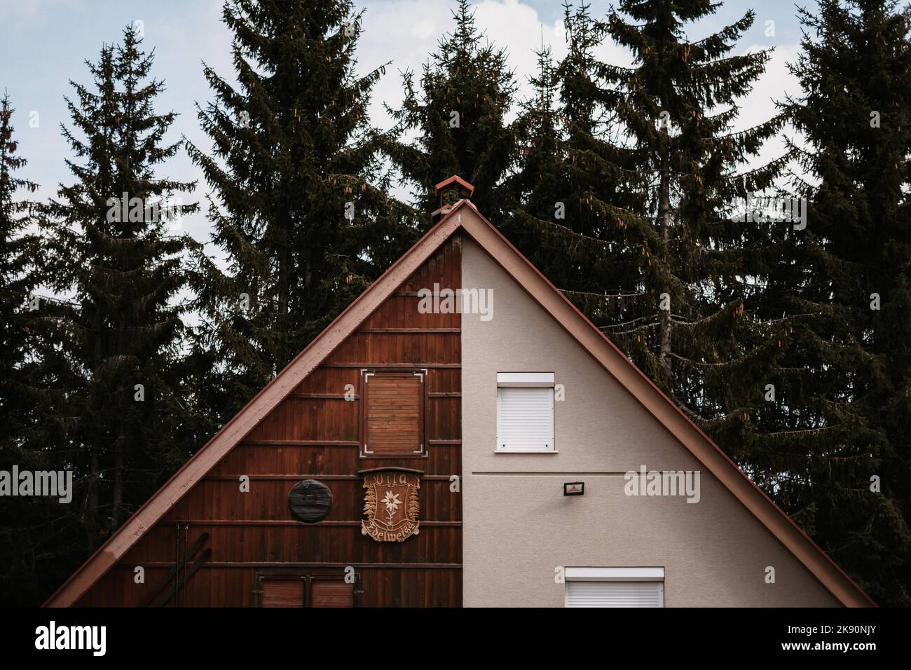 The gable of a countryside house with pine trees in the background ...