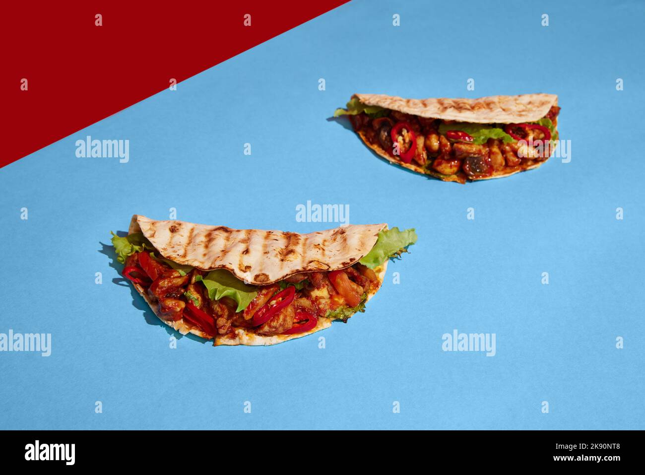 Mexican cuisine. Appetizing and juicy tacos on red-blue background ...