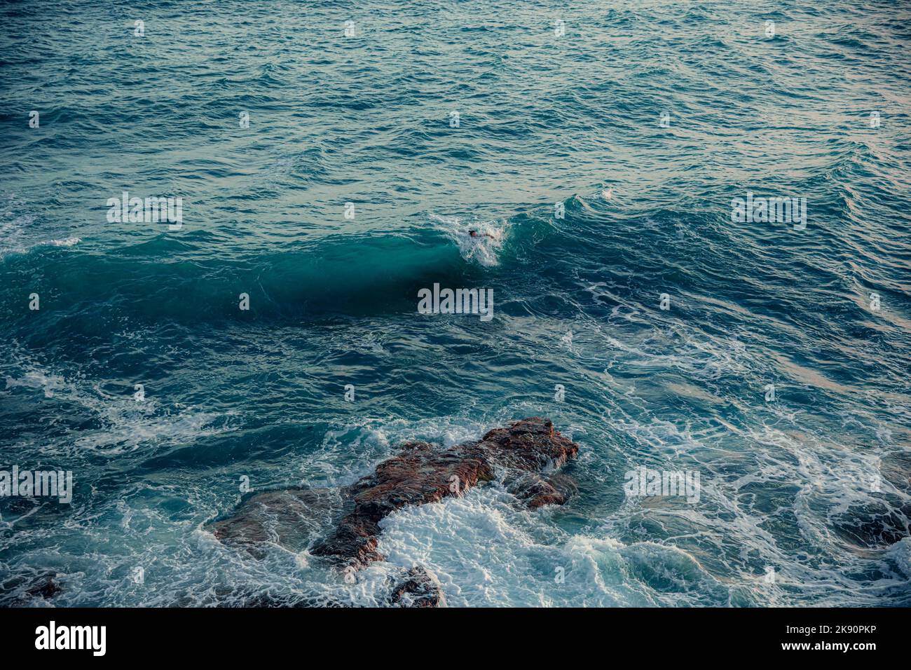 A beautiful view of a wavy ocean washing up the rocky shore Stock Photo ...