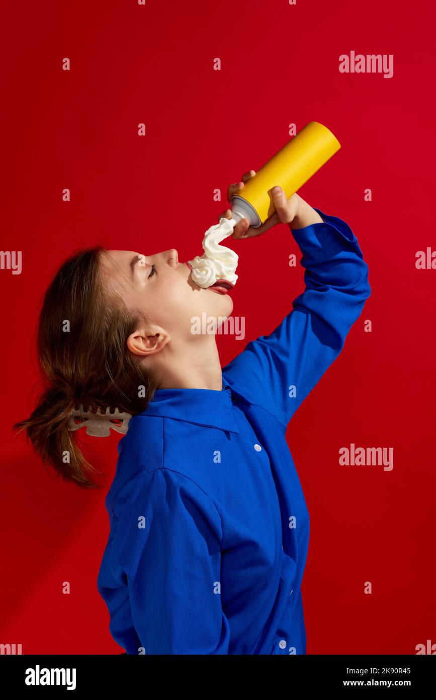 Weird people concept. Young girl tasting sweet whipped cream isolated ...