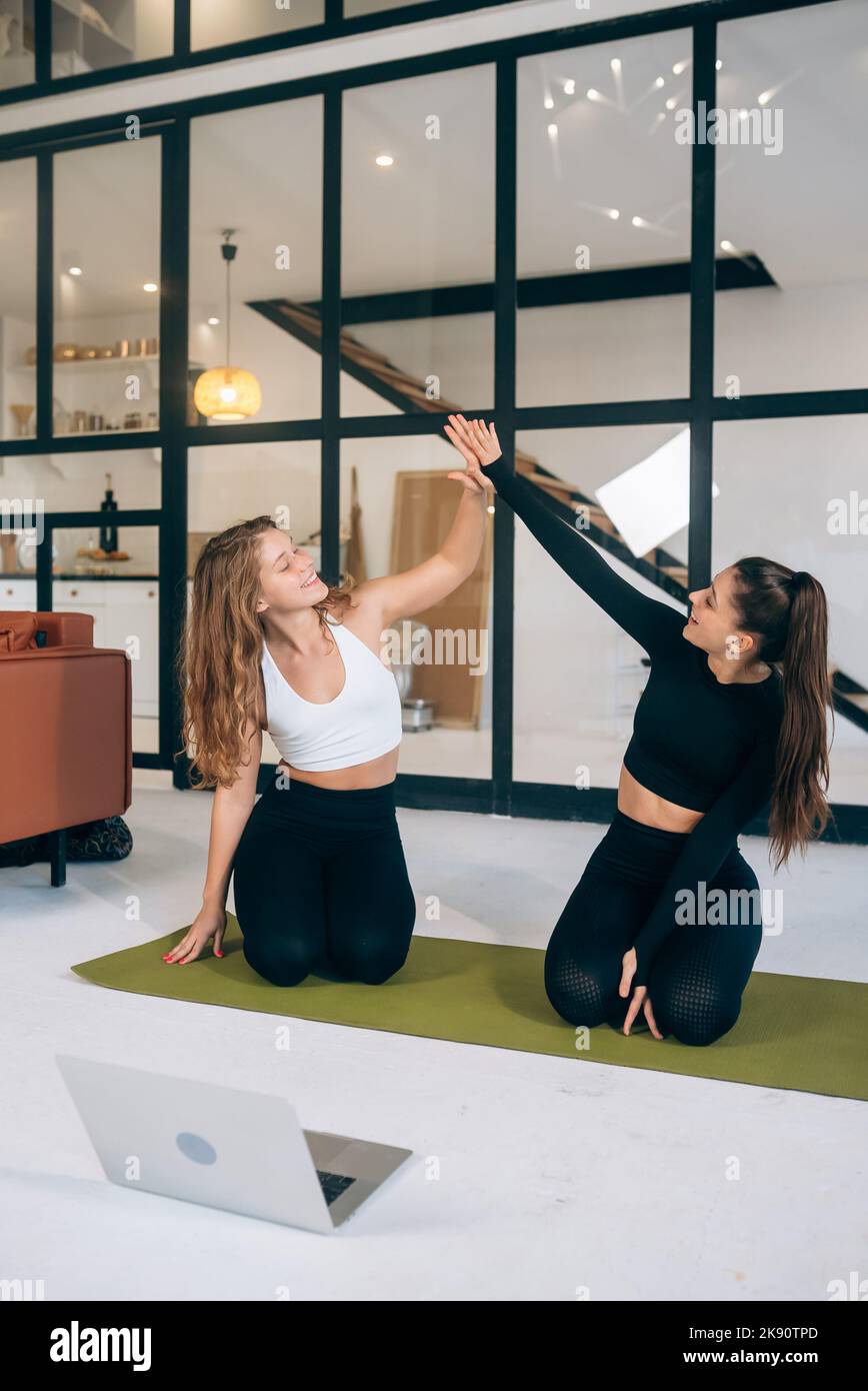 Two women while sitting in the lotus position give a high five Stock ...