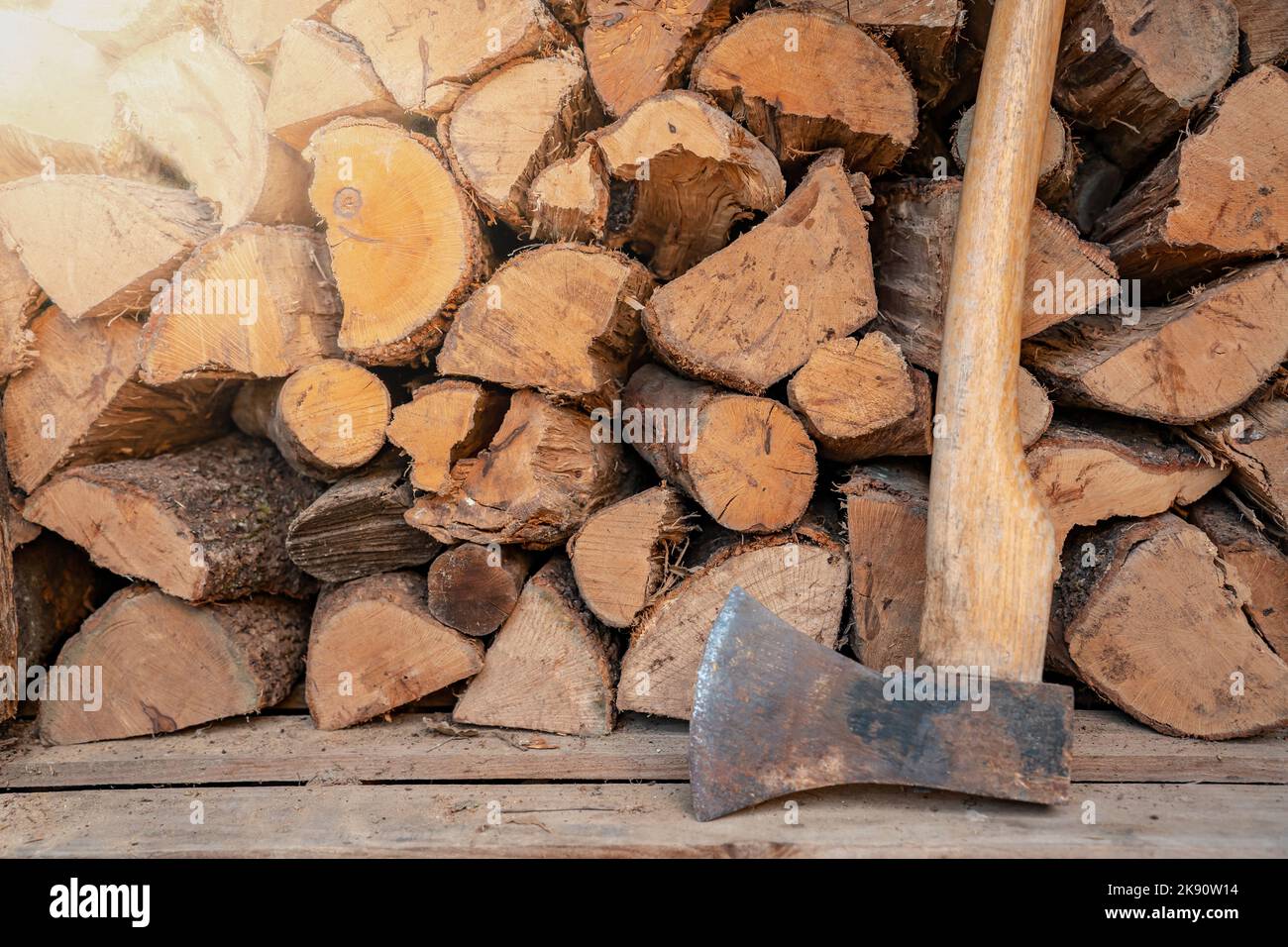 Axe in front of a stack of wood in a woodshed. Natural background Stock ...