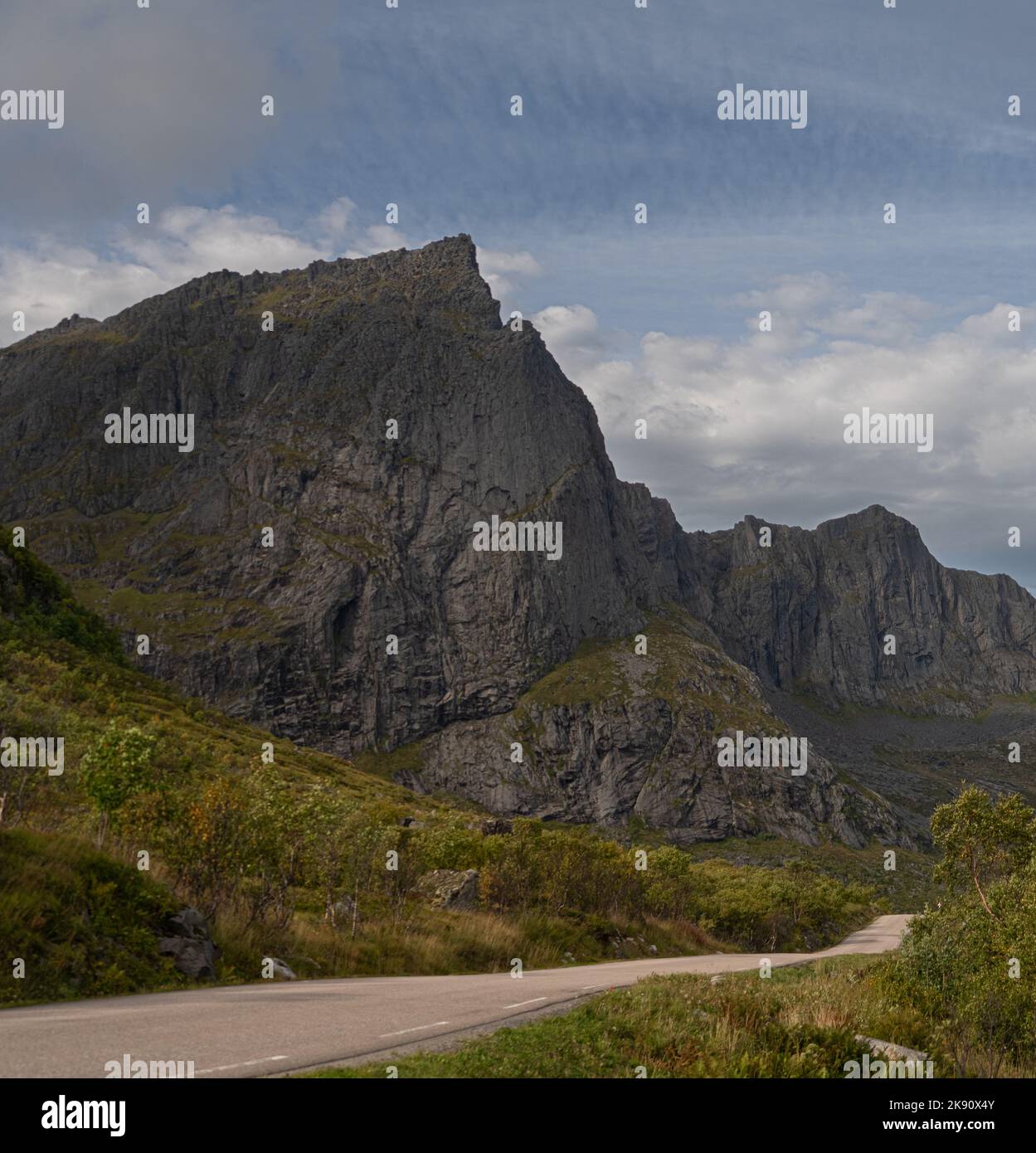 A mountain in front of a highway road with heavy clouds in the ...