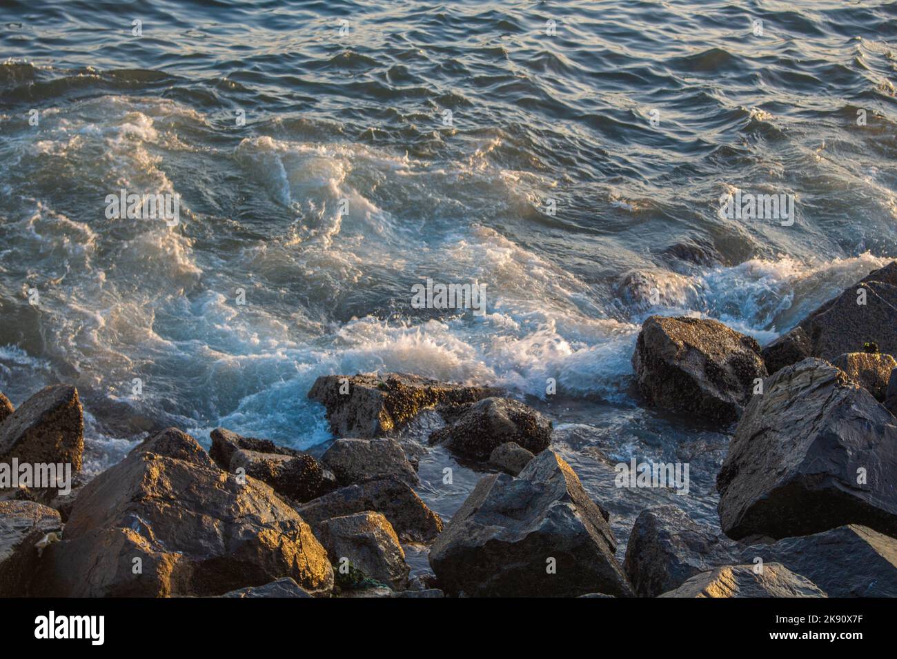A pile of rocks at a beach in Chimbote, Peru with the sea tides washing ...