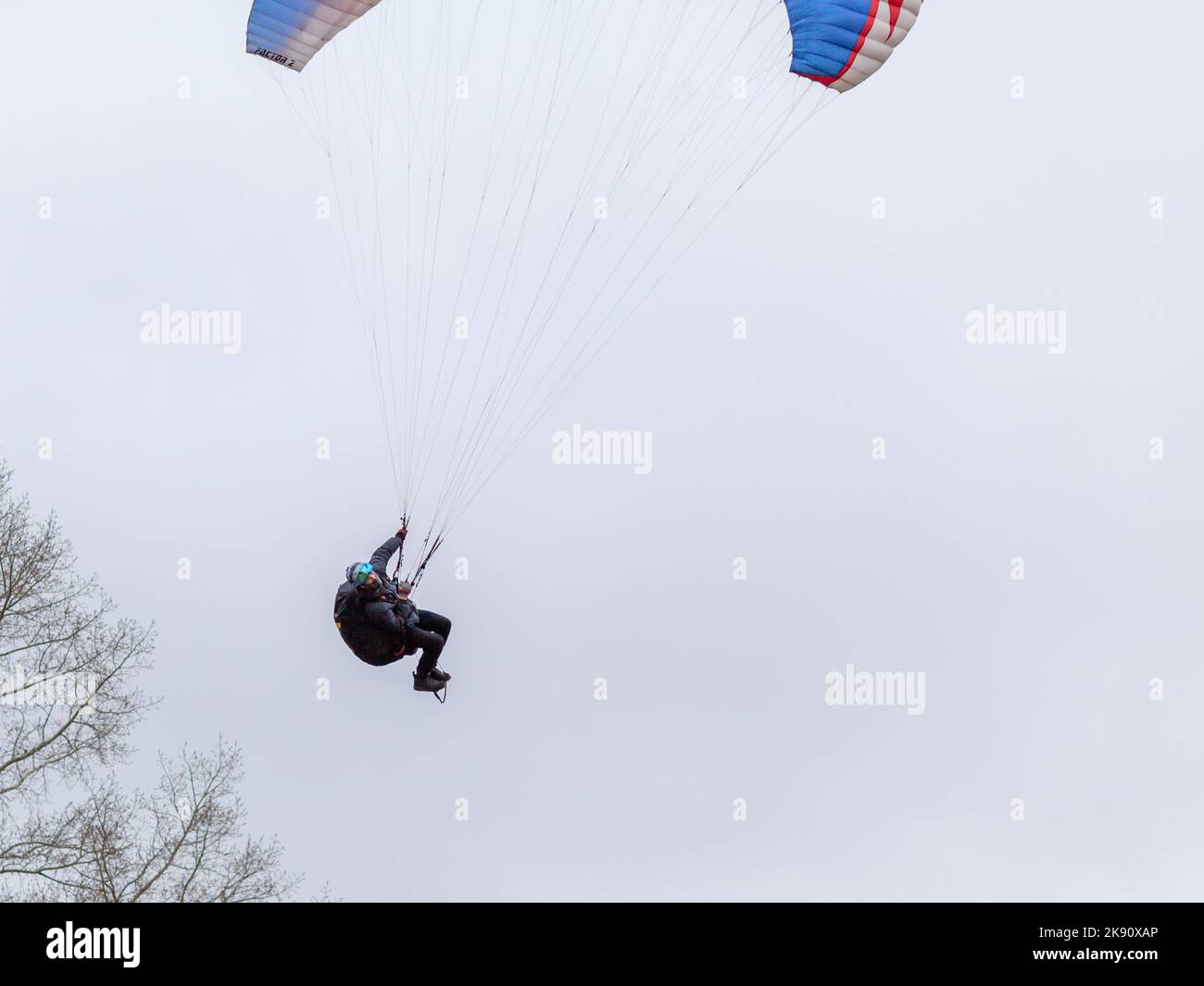 Skydiving extreme sports- parachutist with a parachute unfolded. The sportsman flying on a ...